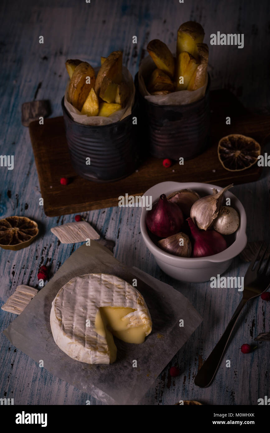 Vertical photo of grilled melted camembert. Hot cheese is placed on ...