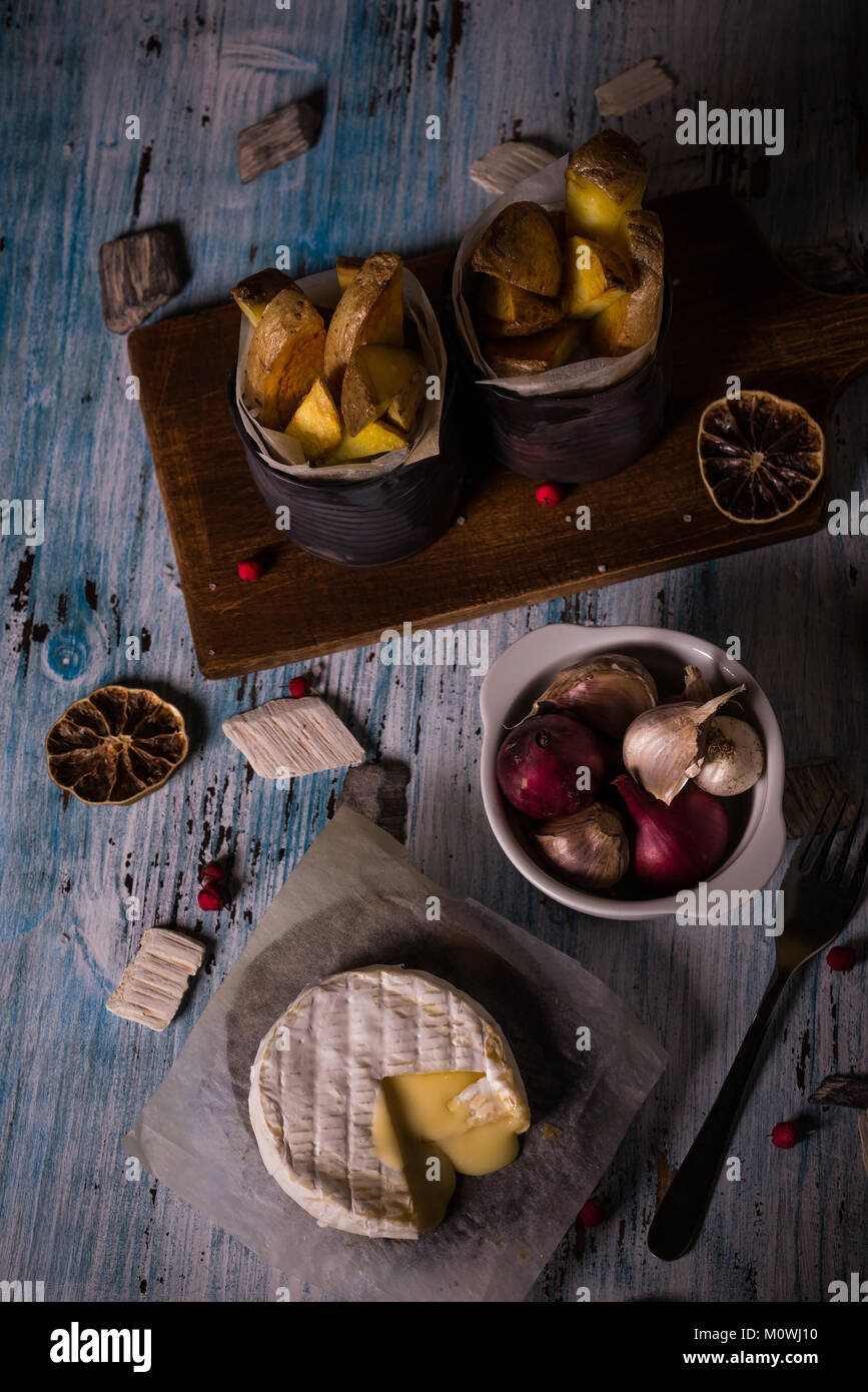 Vertical photo of grilled melted camembert. Hot cheese is placed on ...