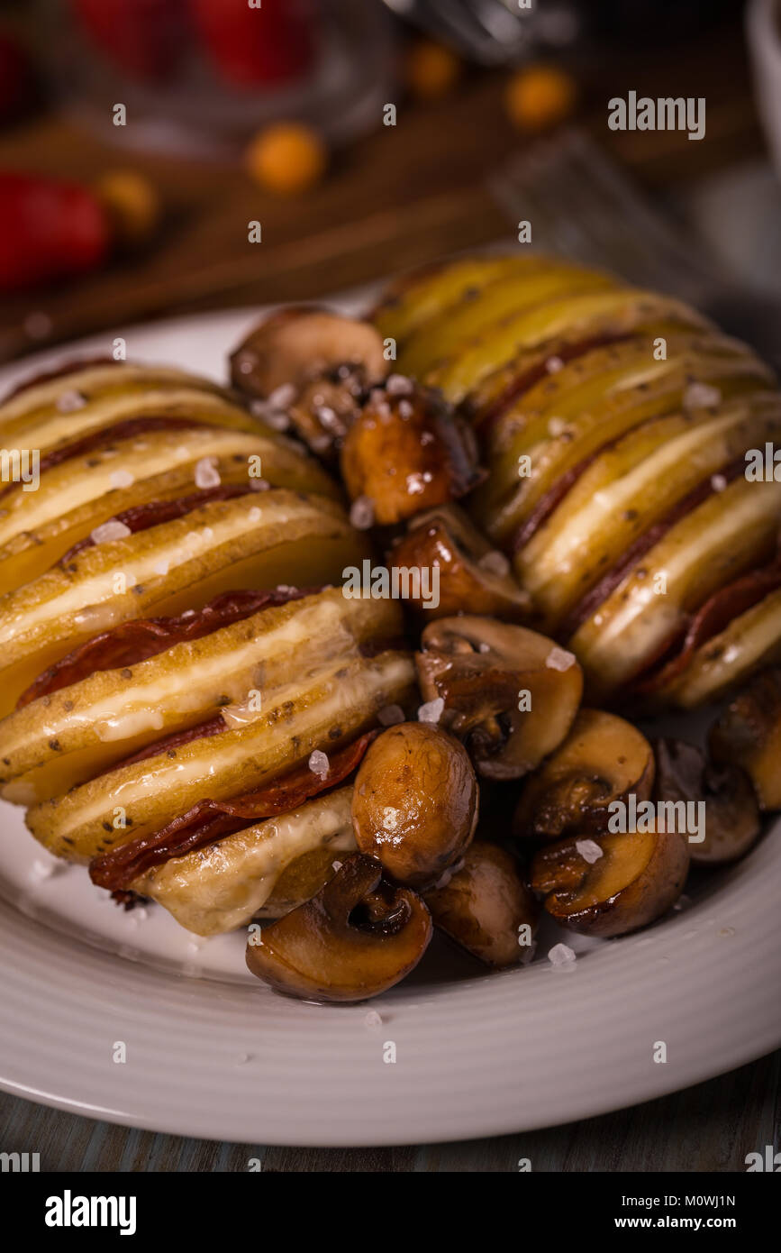 Vertical photo of fried potatoes. Two whole potatoes are sliced and ...