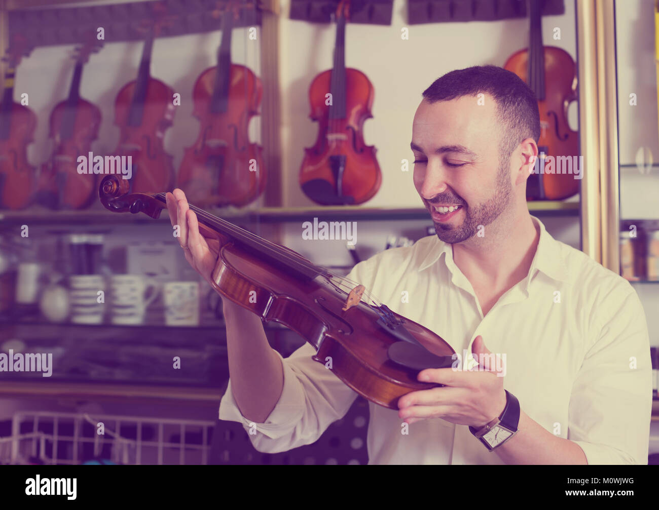 Male musician choosing violin in music instruments studio Stock Photo ...