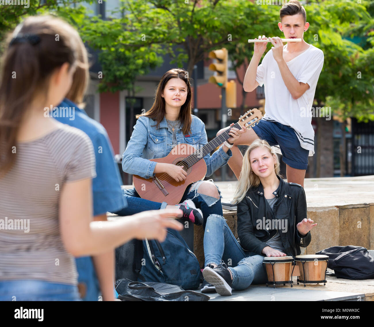 Company of young friends musicians with instruments in park on summer ...