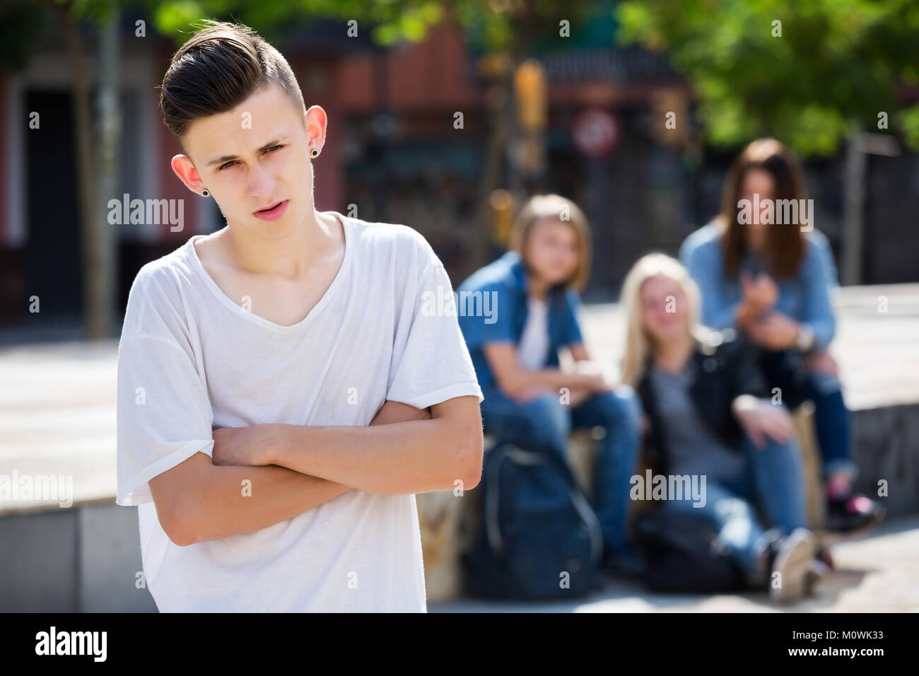 Lonely teenager standing away from friends feeling depressed Stock ...