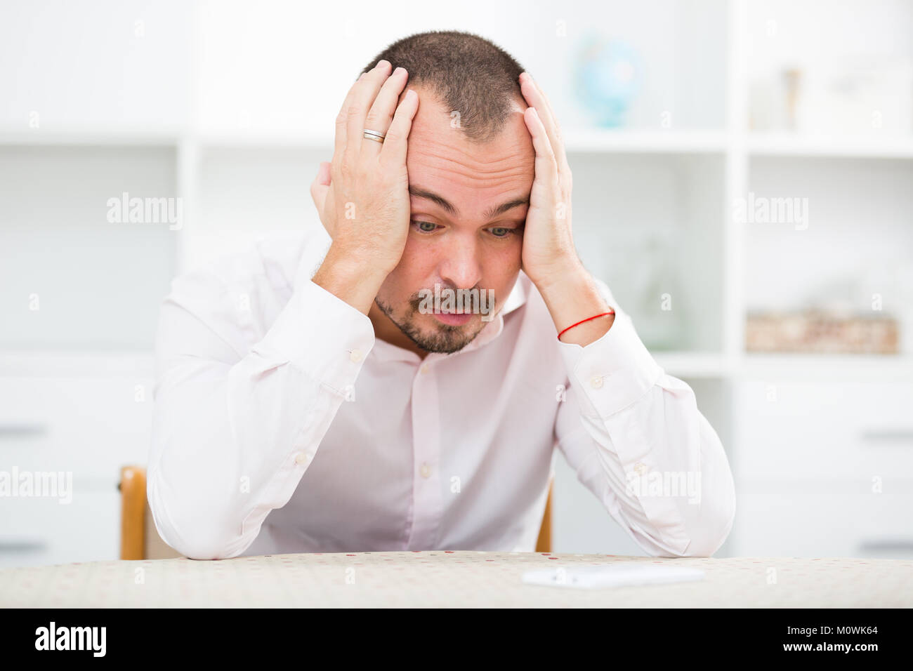 Disappointed worker at his office table feeling stressed, thinking and ...