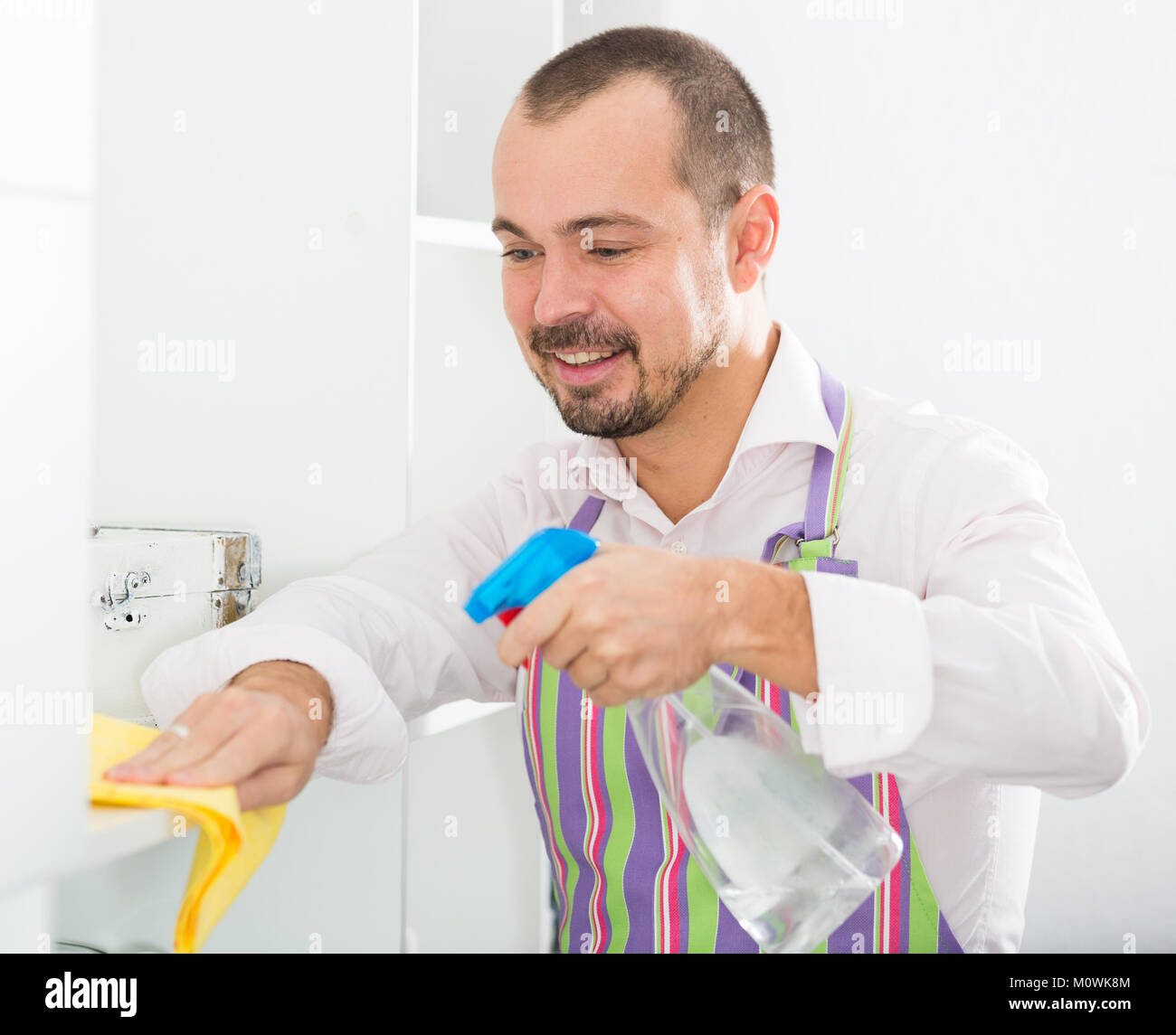 Portrait of smiling young worker making cleaning in special clothing in ...