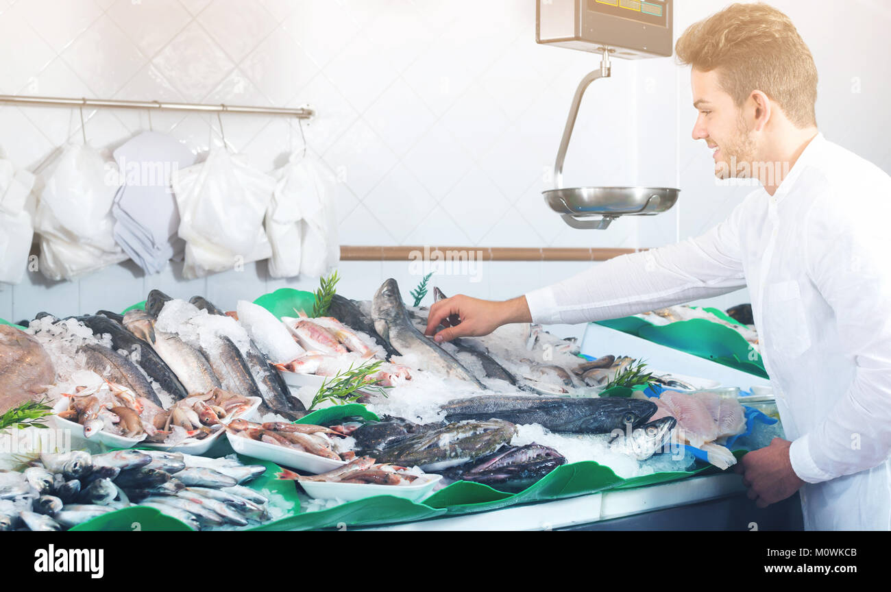 Glad customer buying fish and chilled seafood in shop Stock Photo - Alamy