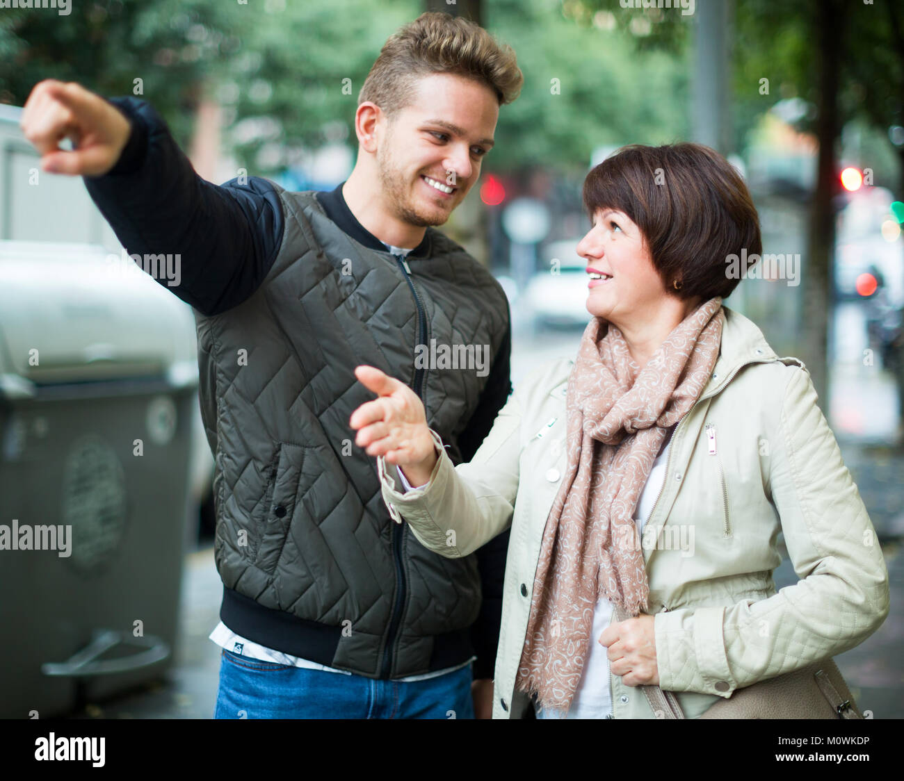 Woman tourist asks for directions from local man points the direction ...