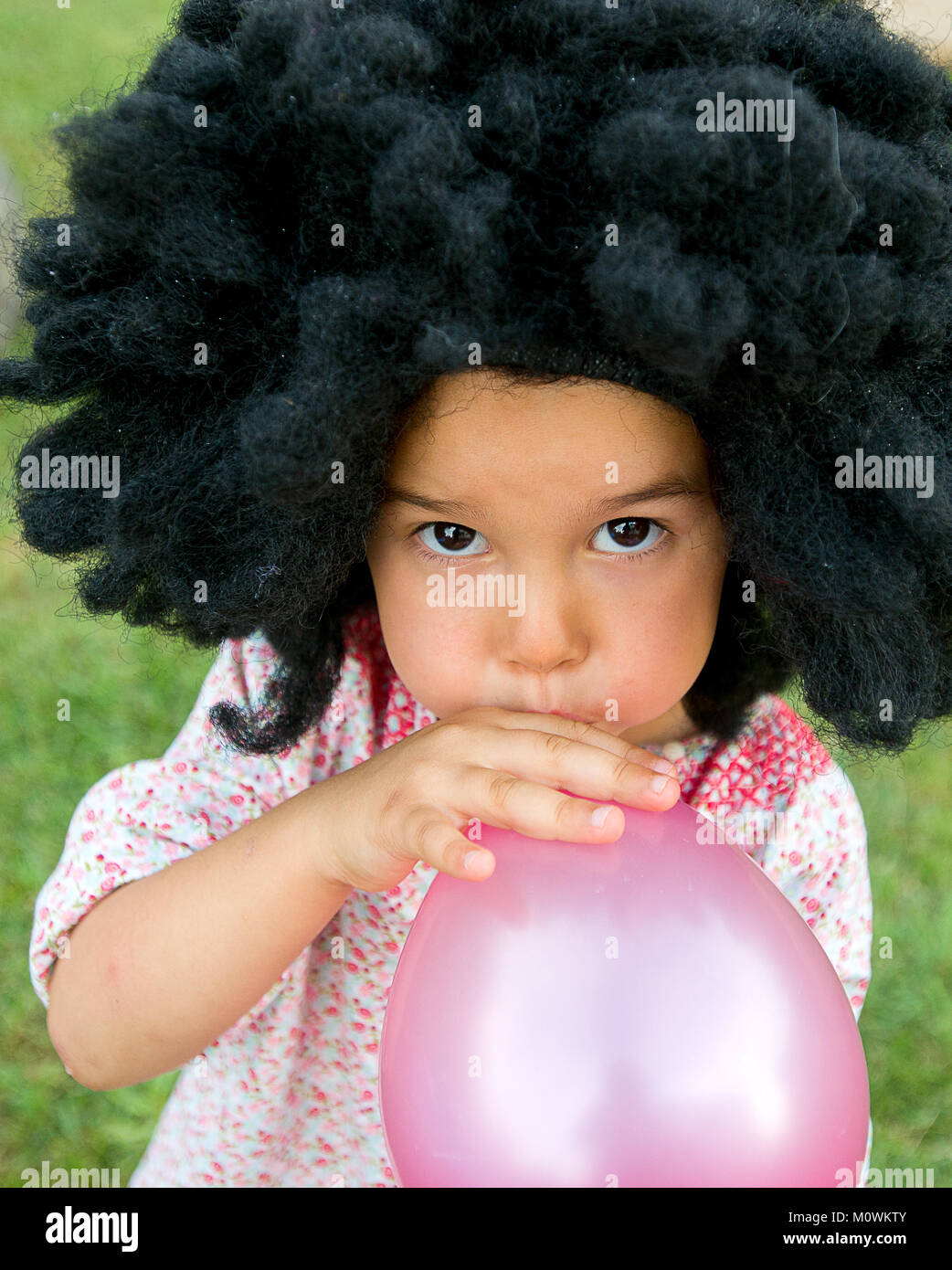 Girl blowing up balloon outdoors hi-res stock photography and images ...