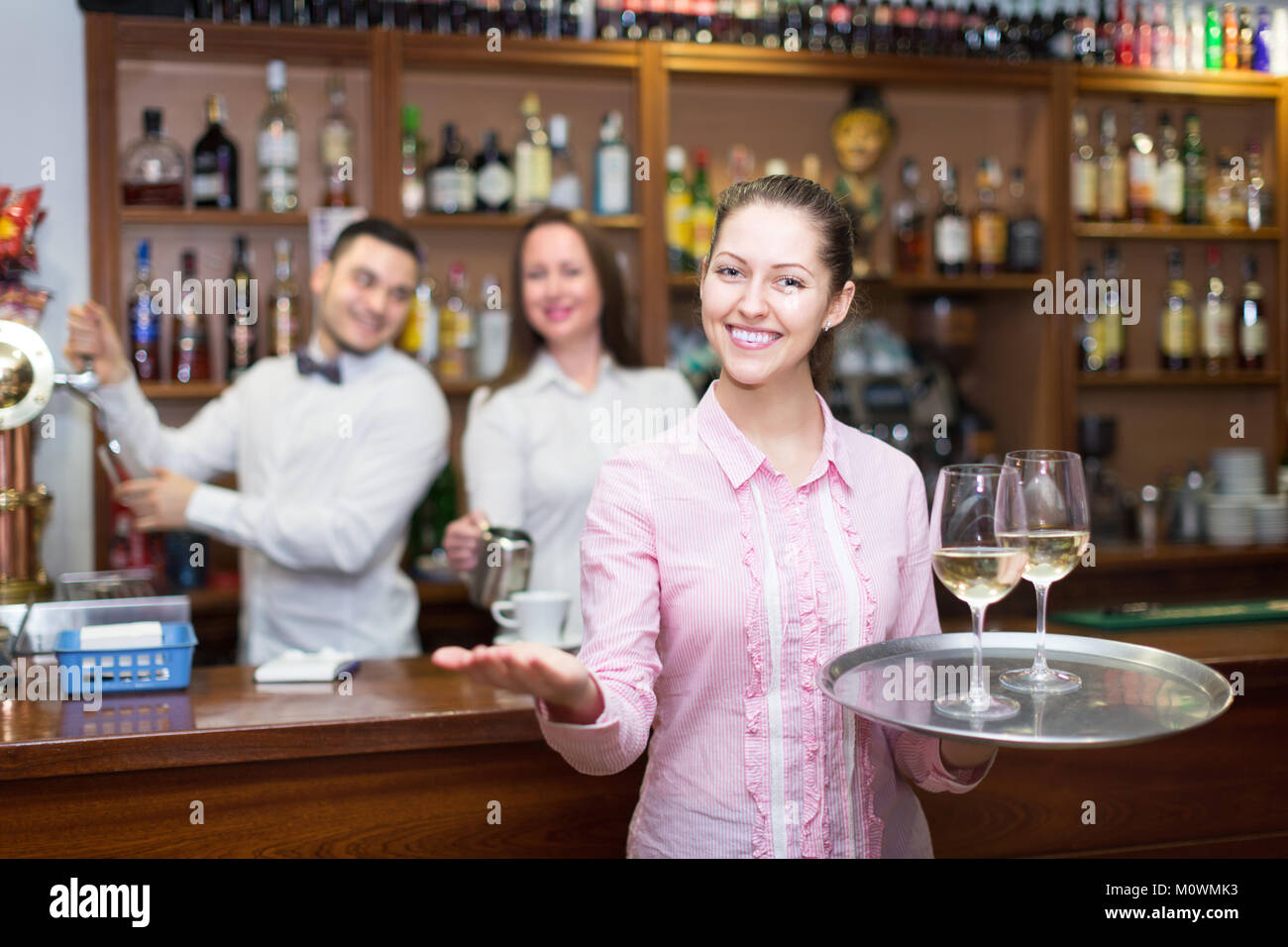 Happy young waitress and smiling barmen working in modern bar Stock ...