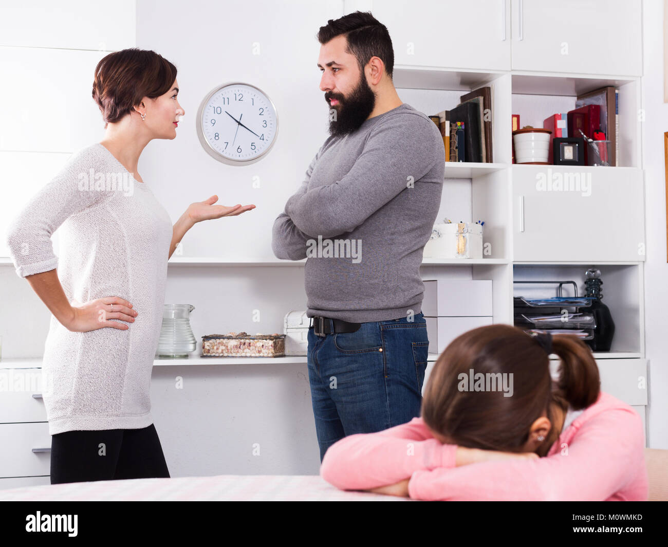 Unhappy father and mother having disagreement while their child at home ...