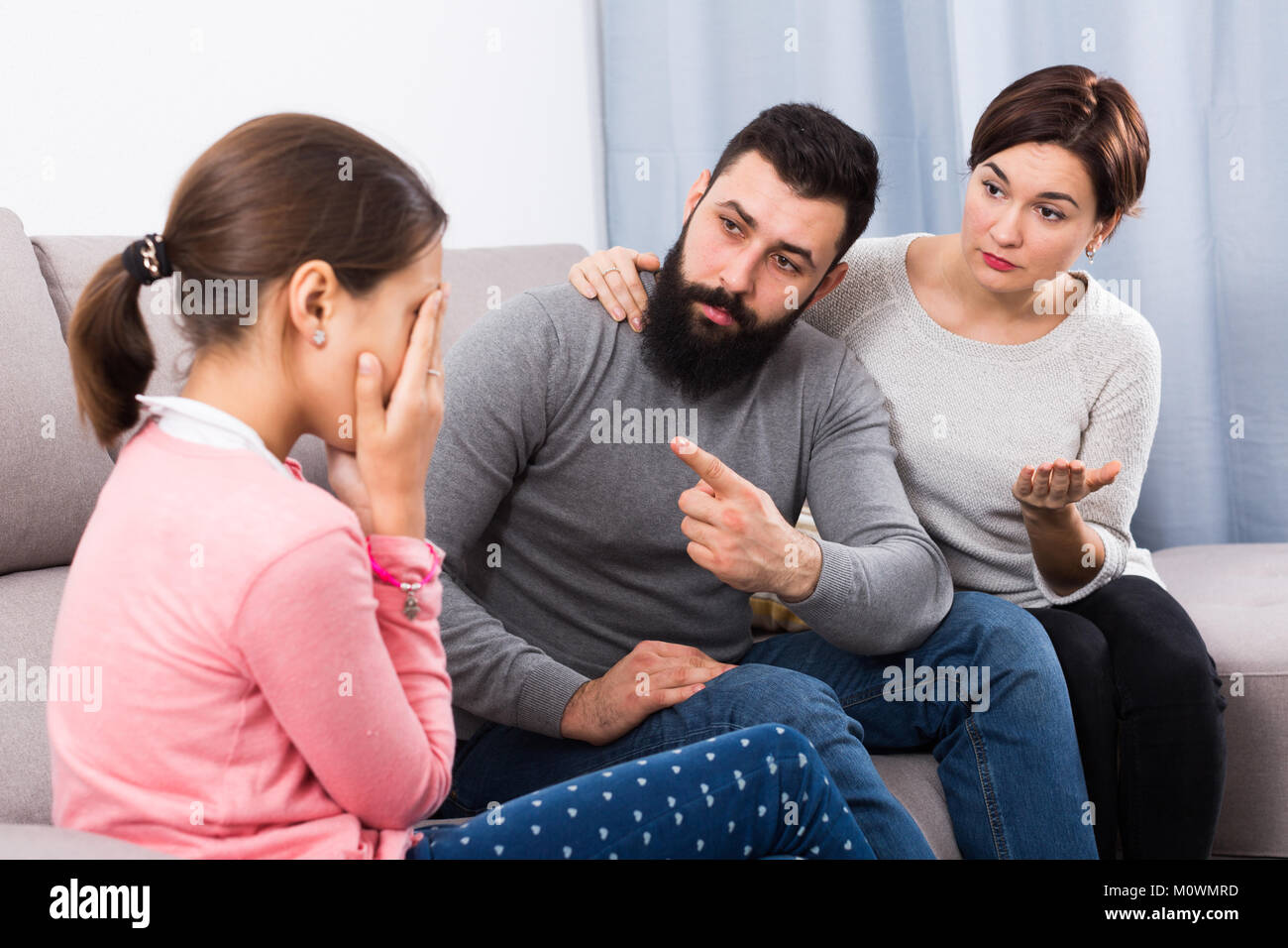 Young parents lecturing their daughter for bad behavior at home Stock ...