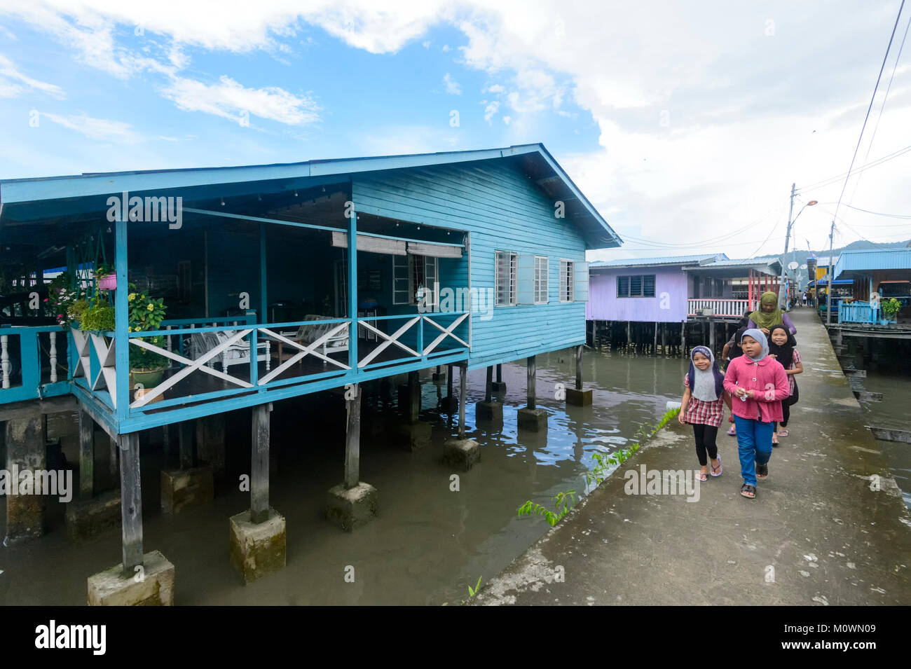 Young Muslim family walking in Sim Sim Water Village, the fishermen's ...