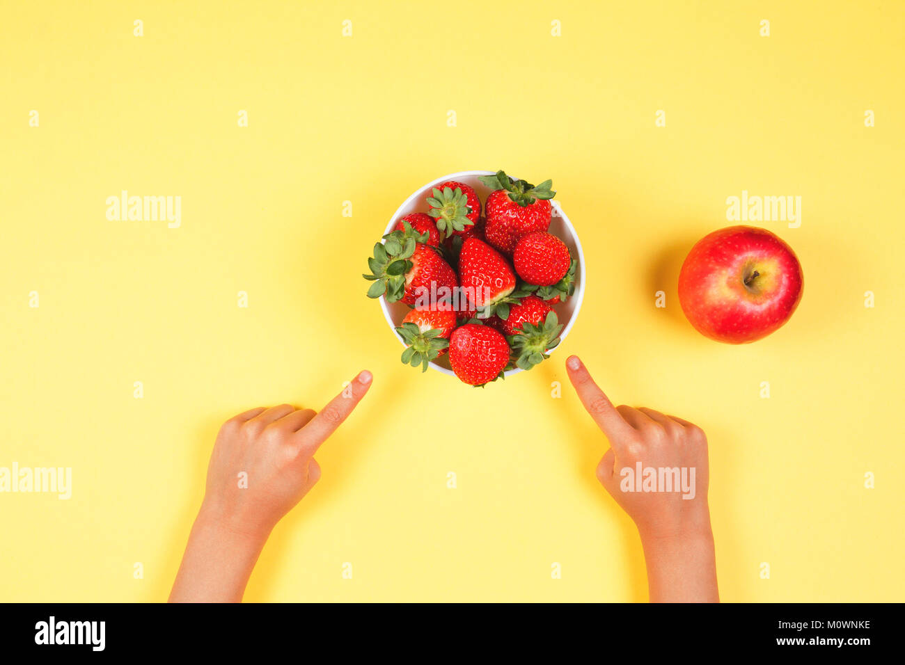 Healthy food concept. Kids hands finger pointing to bowl with fresh ...