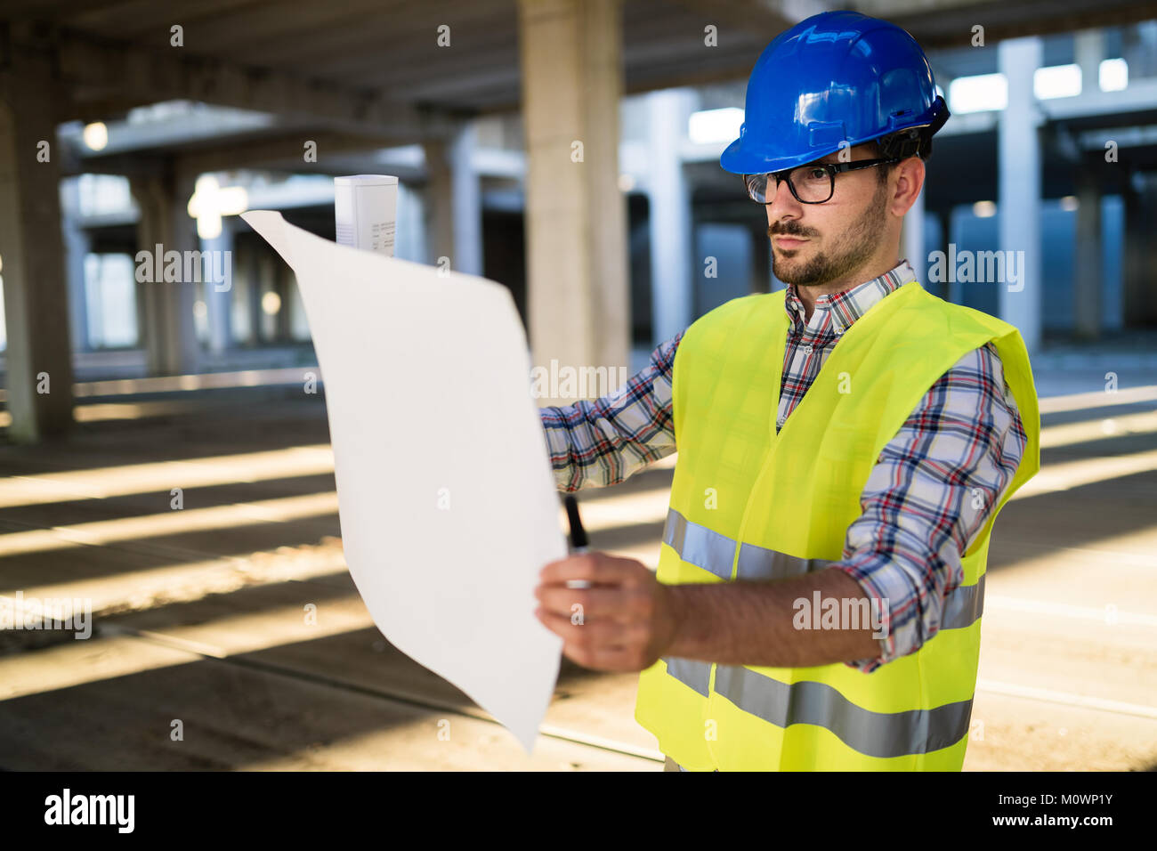 Picture of construction site engineer looking at plan Stock Photo - Alamy