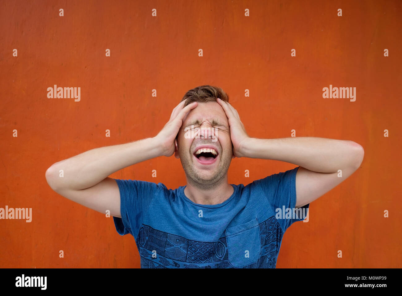 Caucasian man holding his head with hands. He is lucky and fuul of joy ...