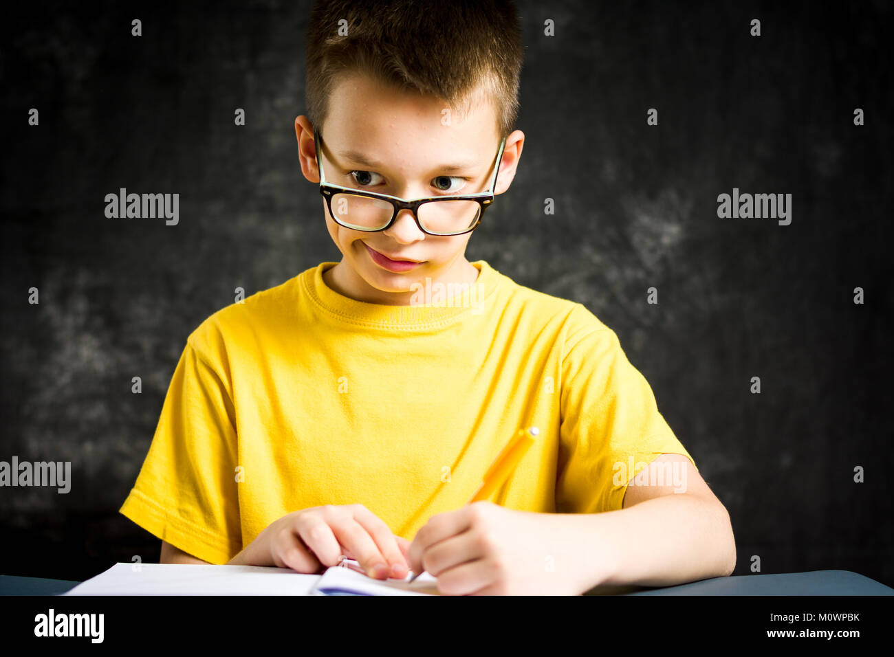 Boy making faces while studying for homework Stock Photo - Alamy