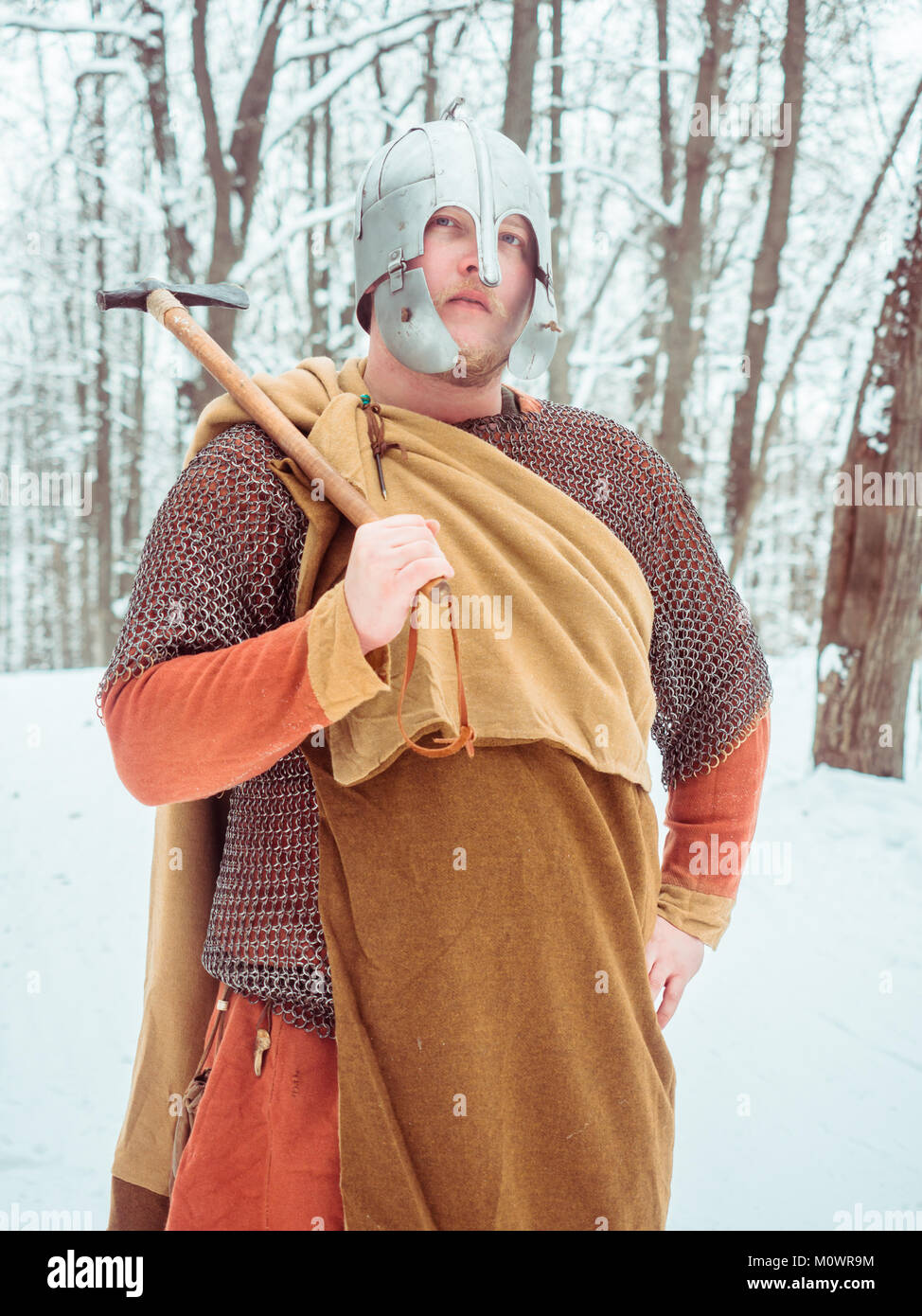 Medieval Irish warrior in mail and helmet holds a hammer in the winter ...