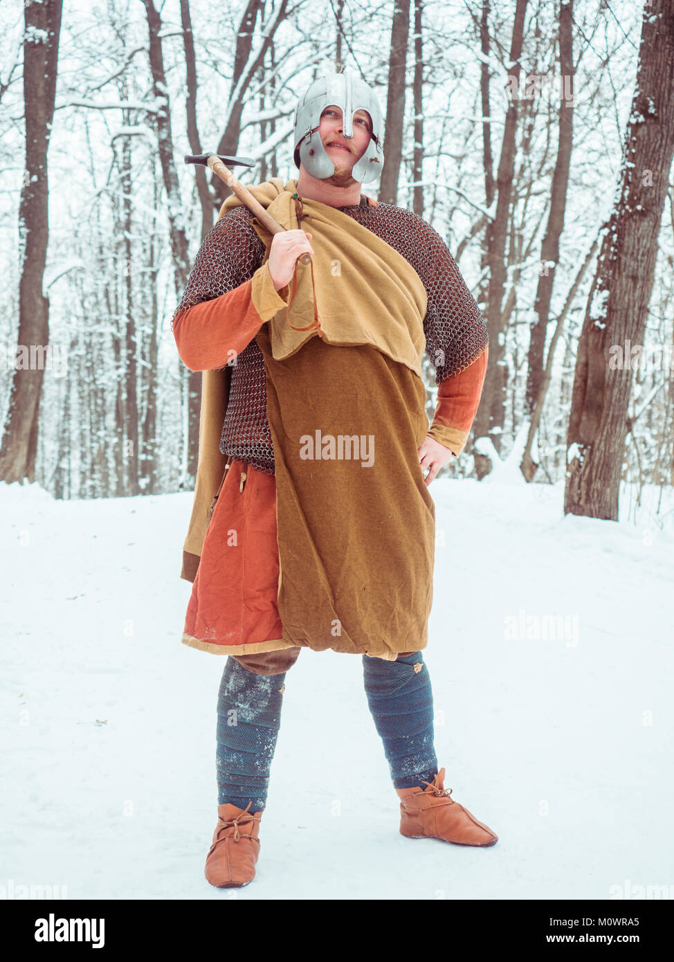 Medieval Irish warrior in mail and helmet holds a hammer in the winter ...
