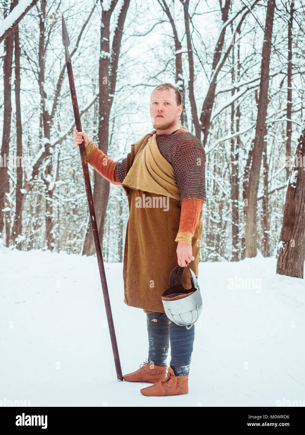 Medieval Irish warrior in chain mail and helmet holds a spear in the ...