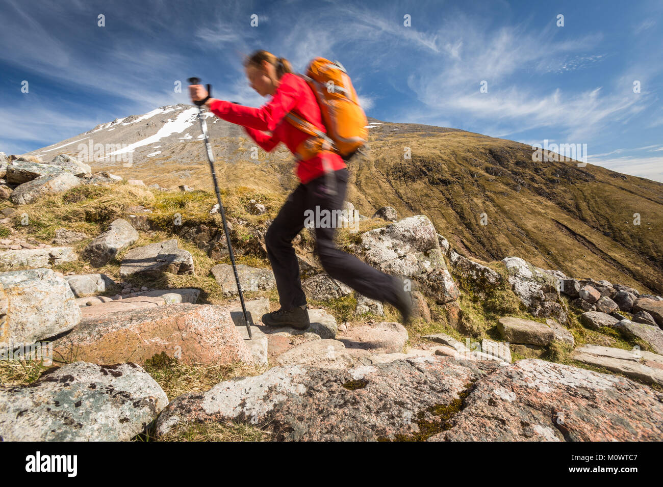 Pretty, young female hiker going uphill Stock Photo - Alamy