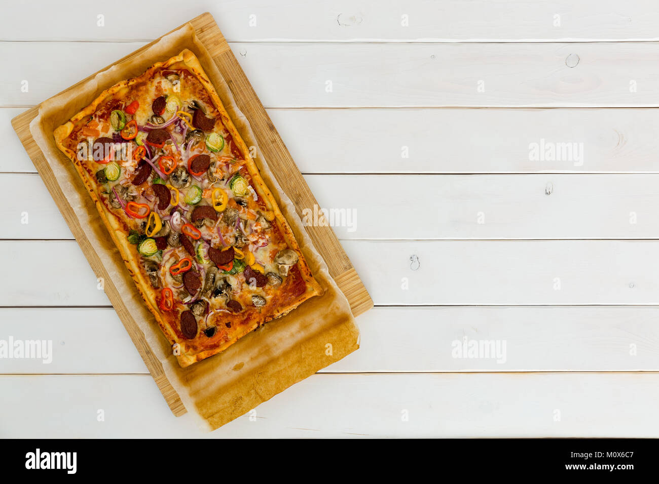 Overhead view of homemade rectangular pizza with vegetable, cheese and ...