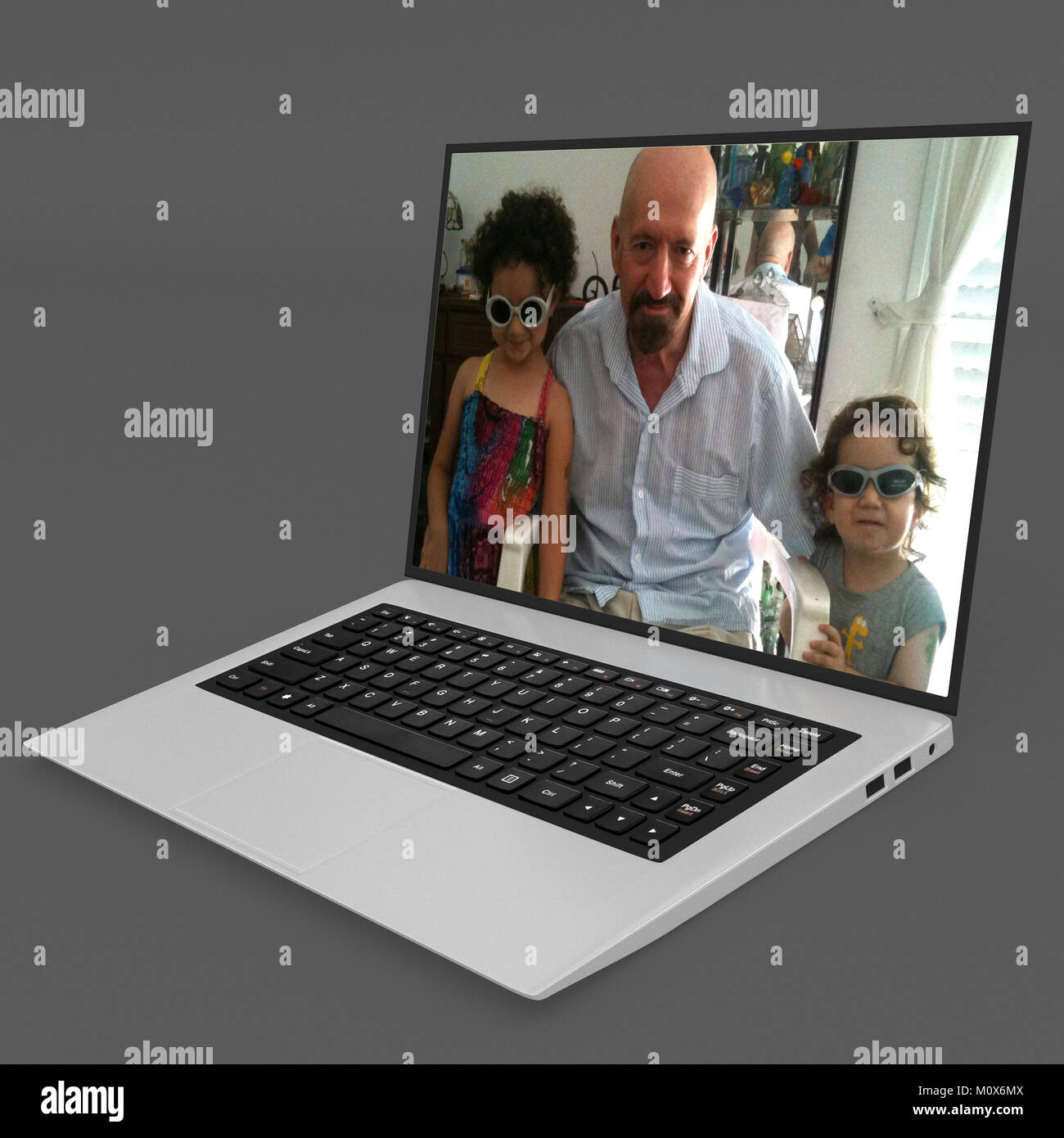 Close-up studio shot of a laptop with a family portrait on display as ...
