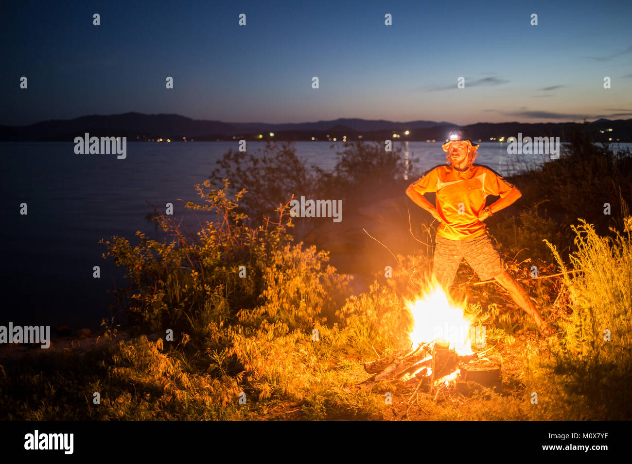 Hiking tourist have a rest in his camp at night near campfire Stock ...