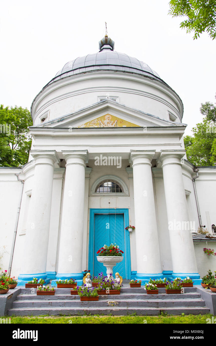entrance to the church. visible steps and white columns. vase of ...