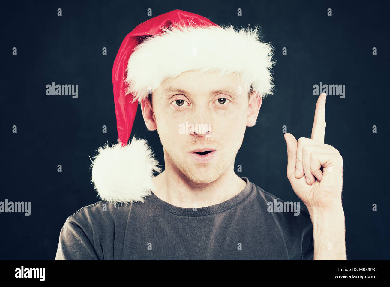 Christmas Man Pointing. Man in Santa Hat Stock Photo - Alamy