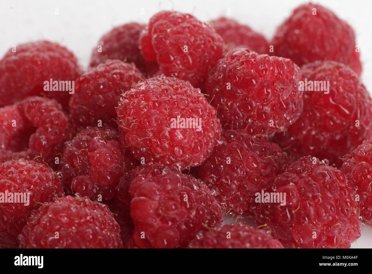 lot of red raspberry on white background Stock Photo - Alamy