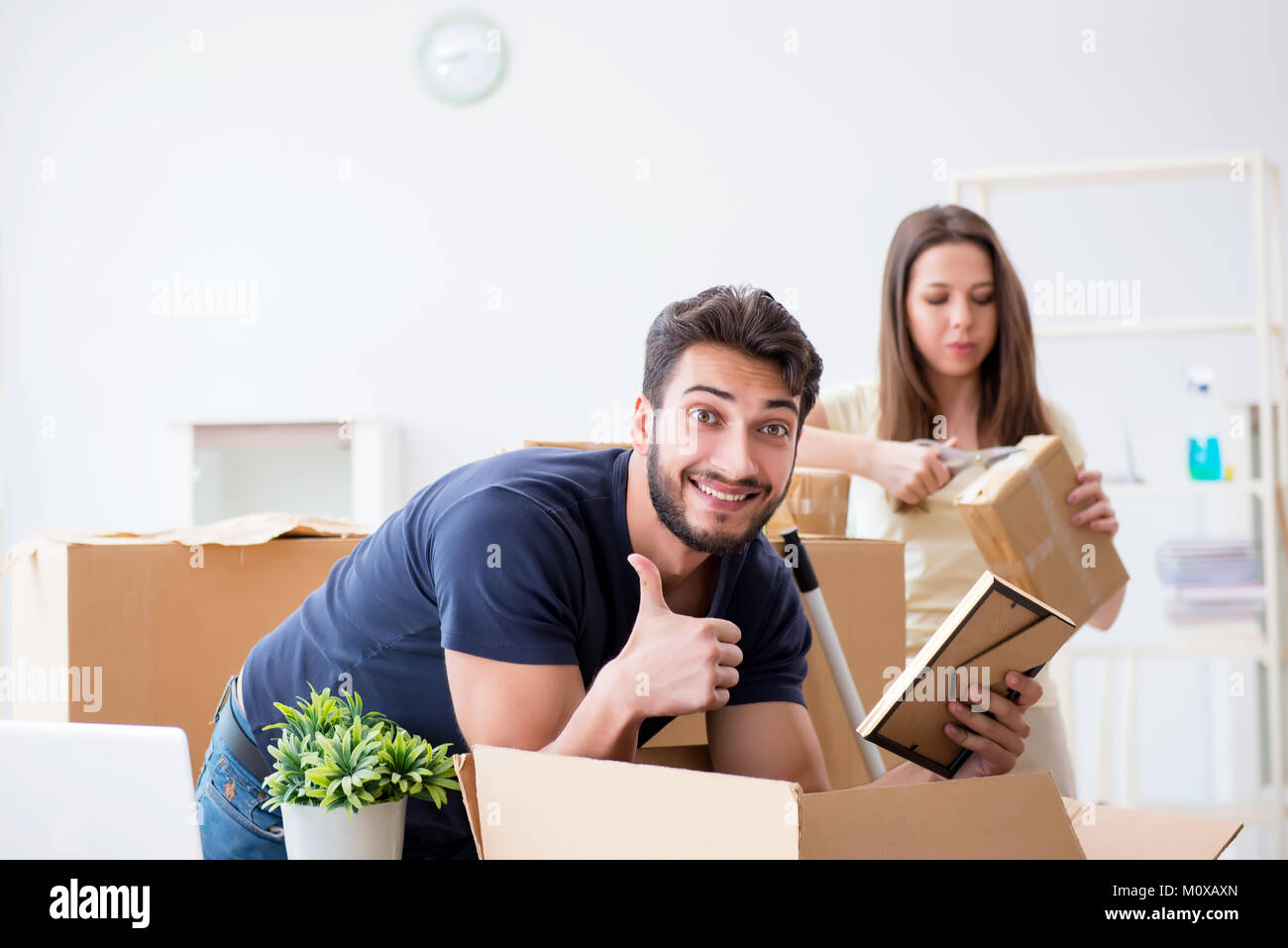 Young family unpacking at new house with boxes Stock Photo - Alamy