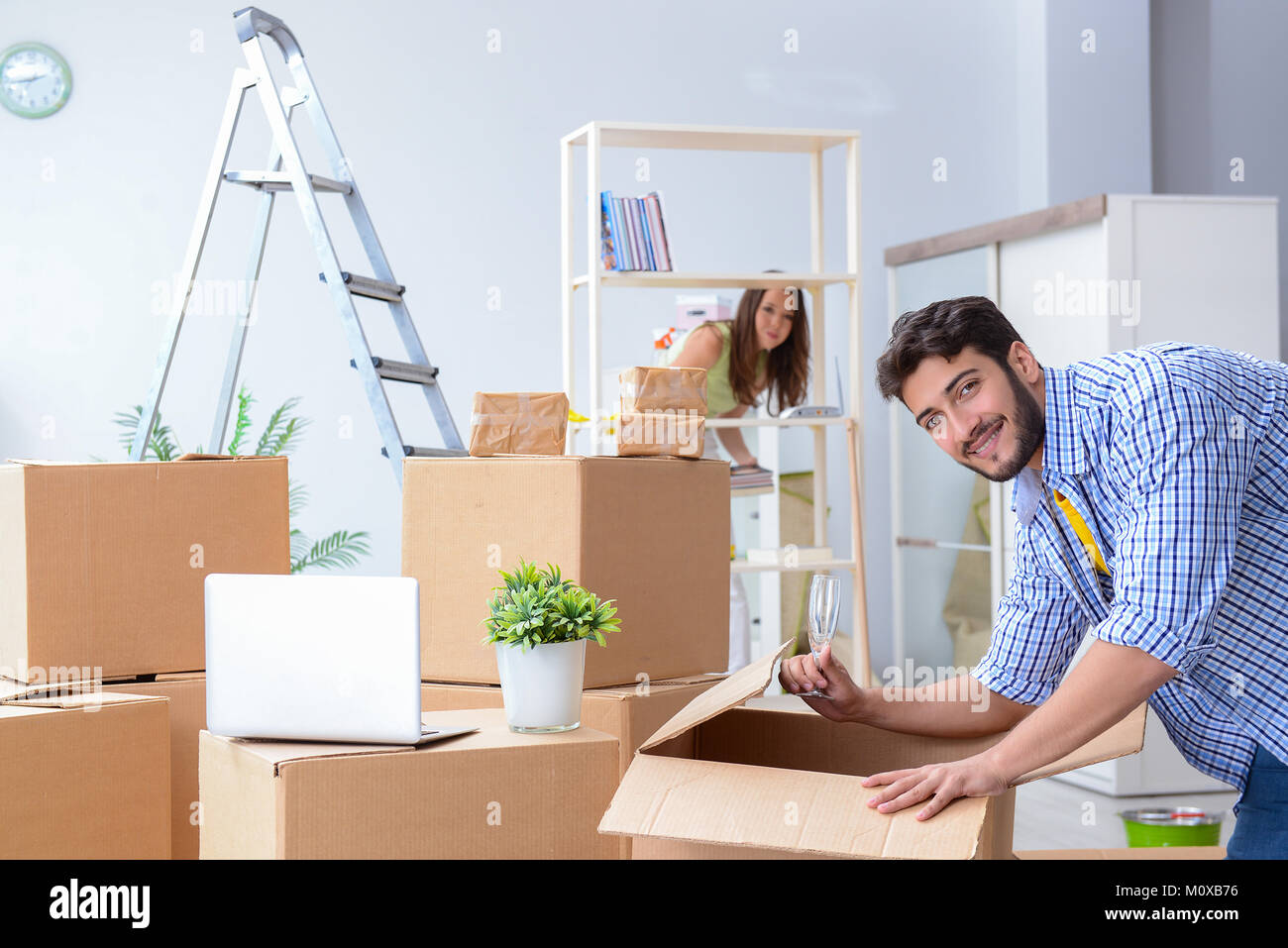 Young family unpacking at new house with boxes Stock Photo - Alamy