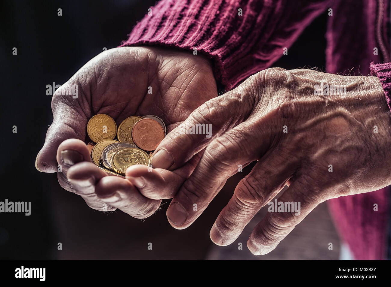 Pensioner man holding in hands euro coins. Theme of low pensions Stock ...