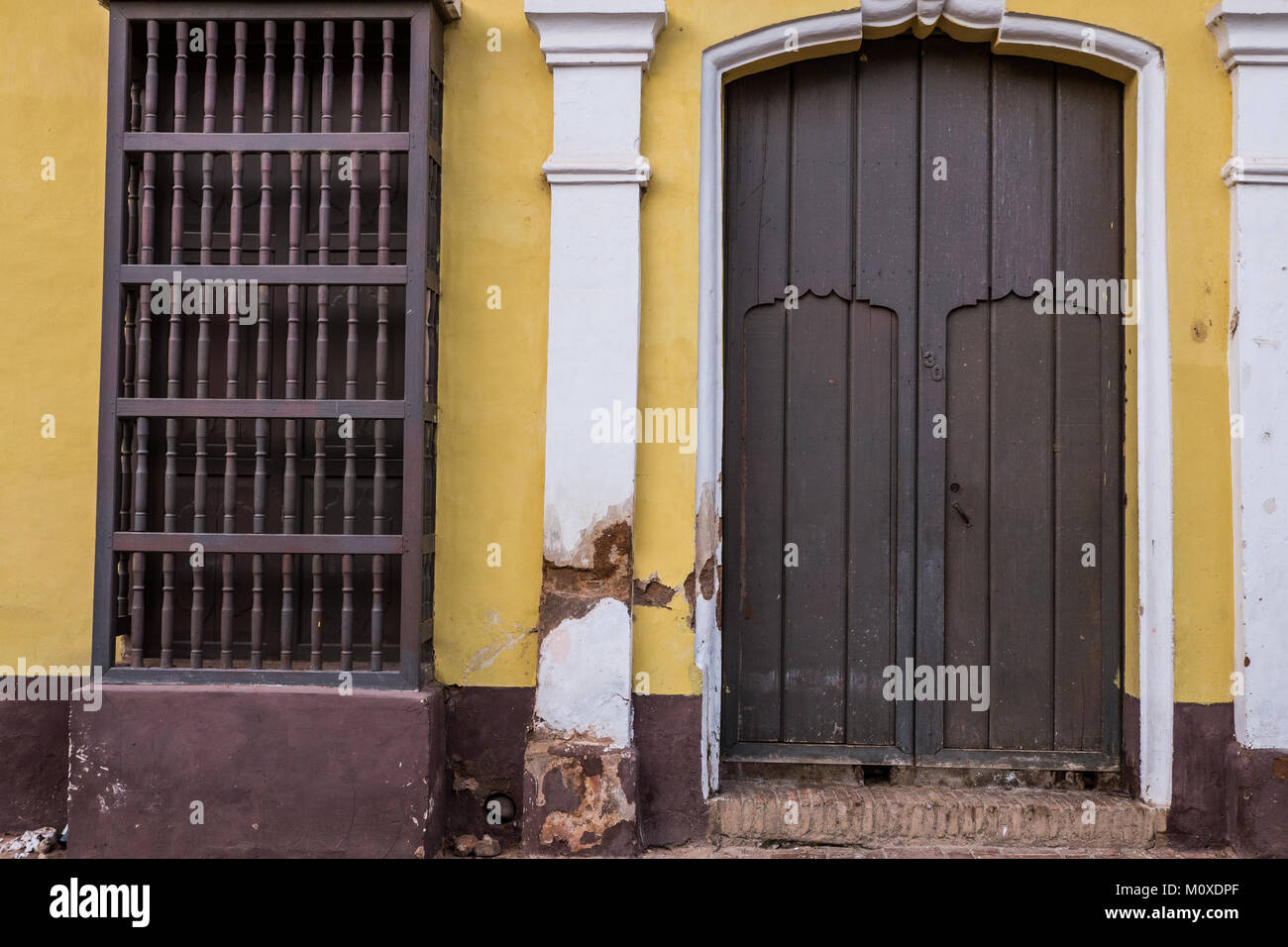 Yellow colonial building with brown doors, windows in Trinidad, Cuba ...