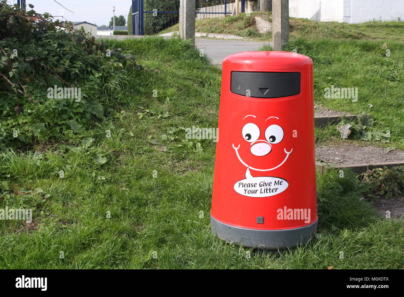 A SUNNY LANDSCAPE TYPE PHOTO OF A LITTER BIN IN AN ENGLISH VILLAGE WITH ...