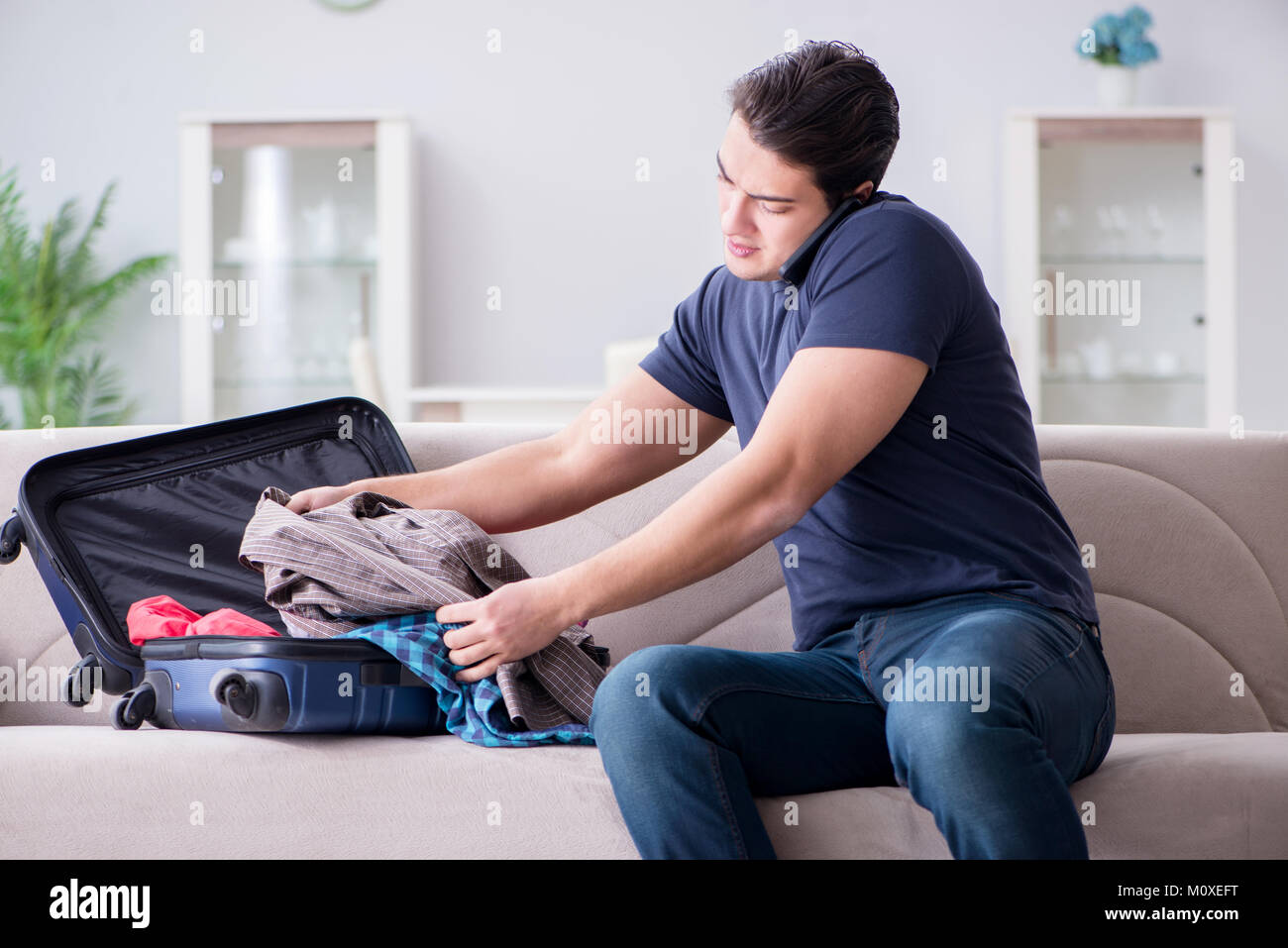 Young man preparing packing for summer vacation Stock Photo - Alamy