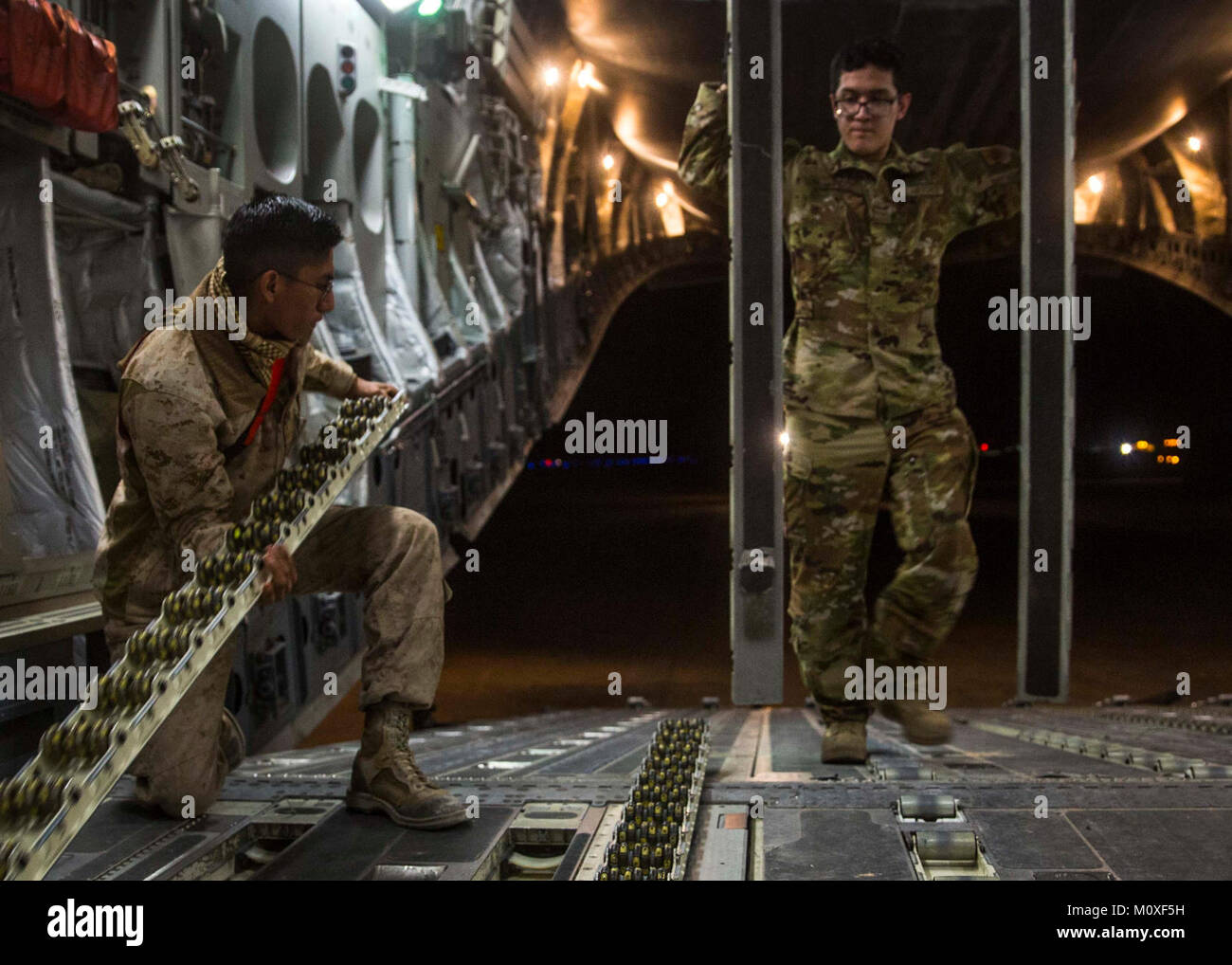 LOCATION, Iraq – A U.S. Marine corporal and an Air Force load master a ...
