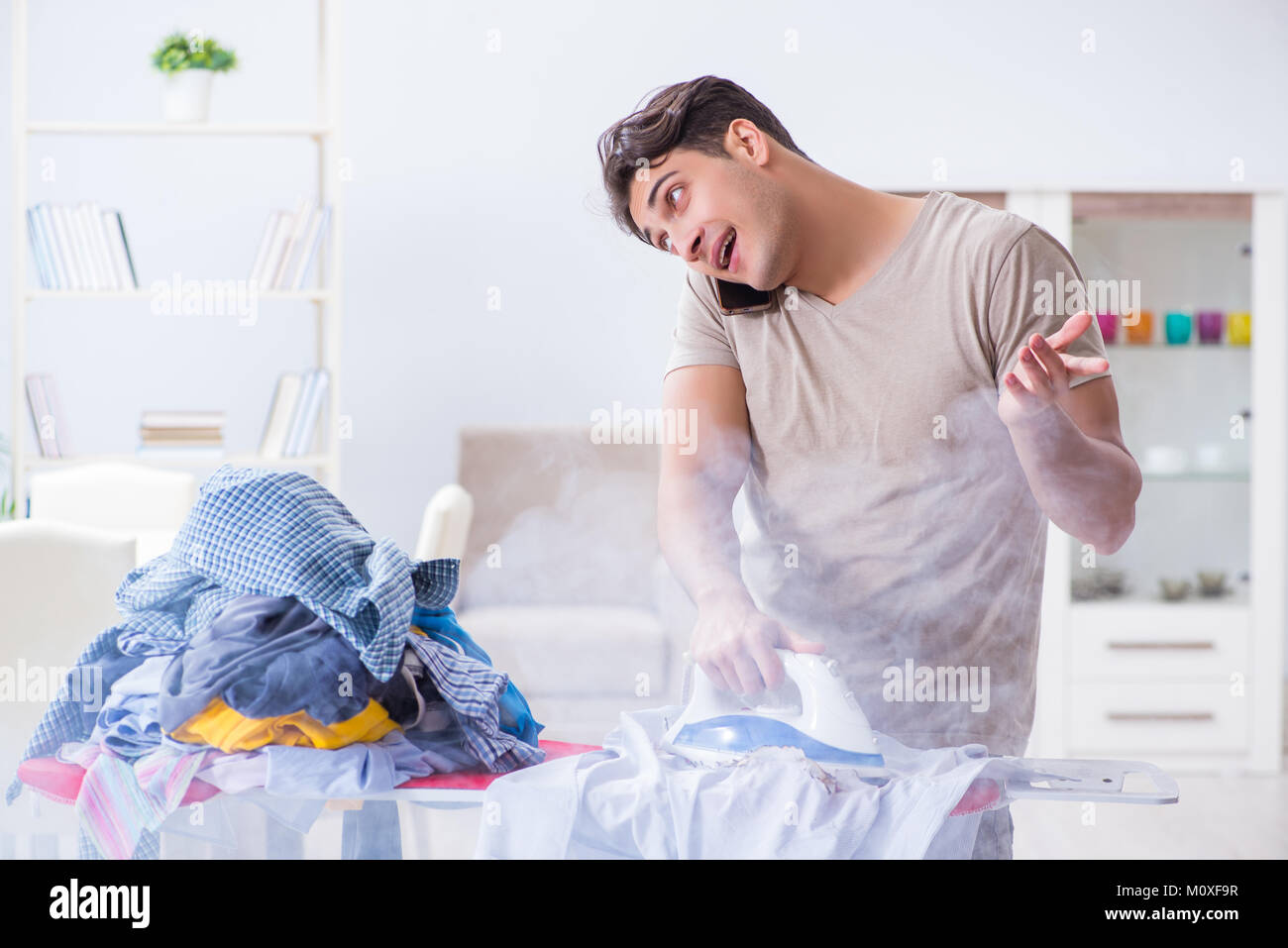 Inattentive husband burning clothing while ironing Stock Photo - Alamy