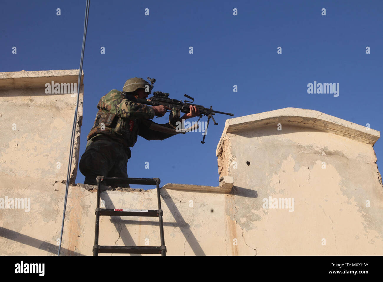 A 7th Special Operations Kandak Commando provides security on a raid in ...