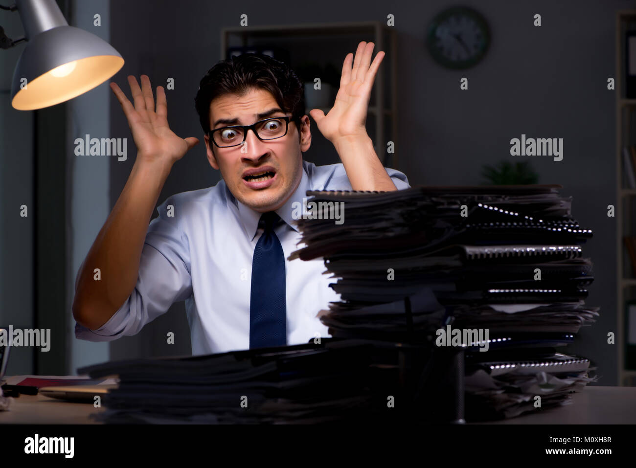 Young businessman working overtime late in office Stock Photo - Alamy