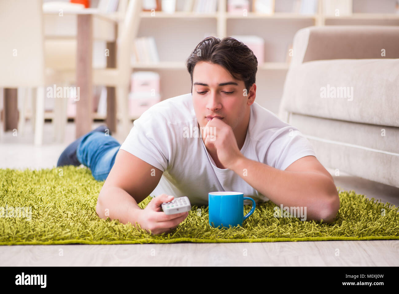 Man watching tv at home on floor Stock Photo - Alamy