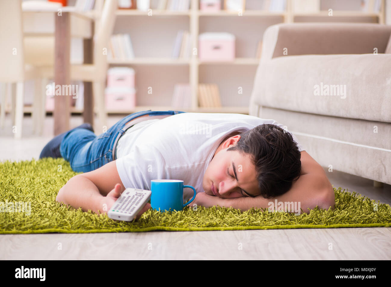 Man watching tv at home on floor Stock Photo - Alamy