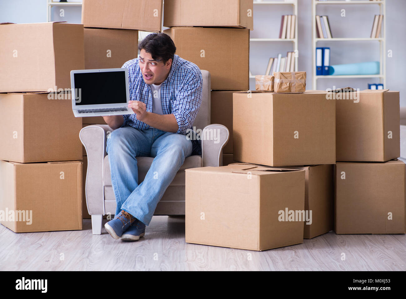 Young man moving in to new house with boxes Stock Photo - Alamy