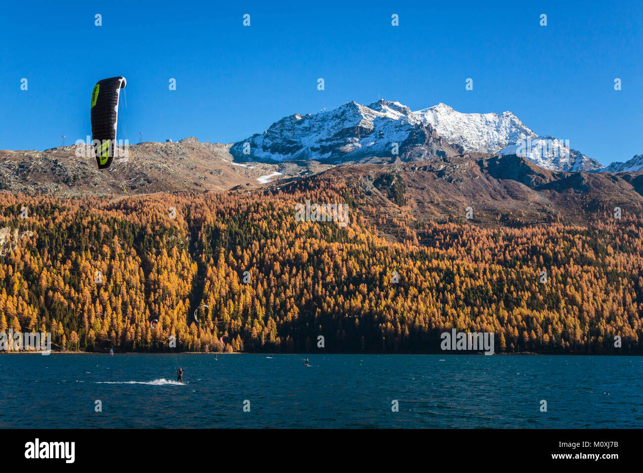 Wind surfing on Lake Silvaplana with fall foliage color in the larch ...