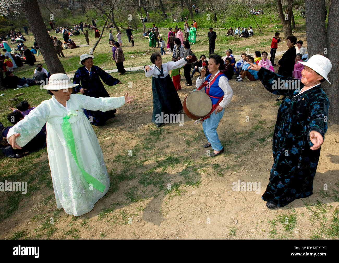 North Korean women dancing in a park for the day of the sun which is ...