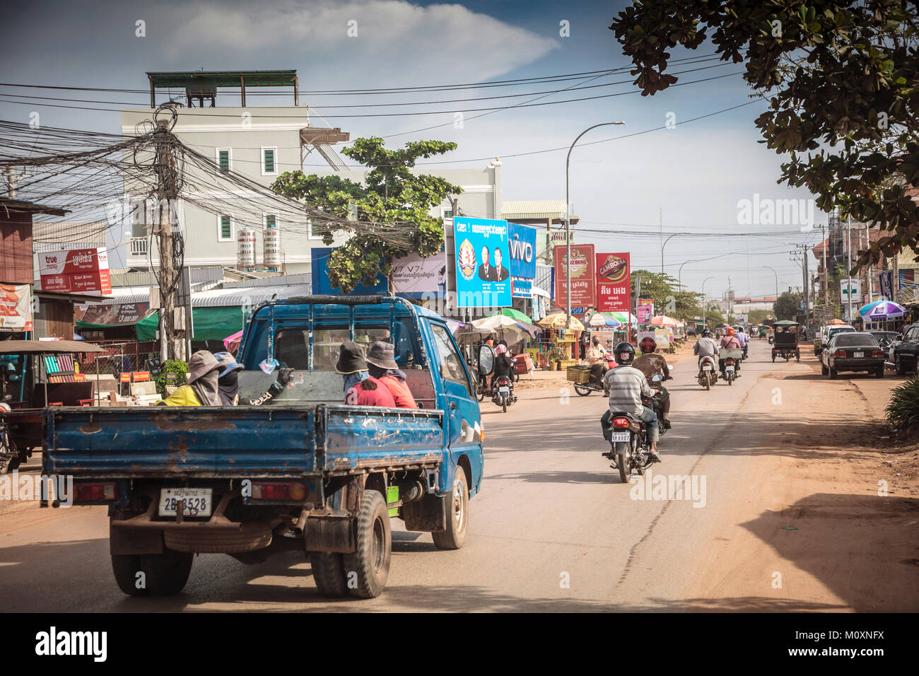 Workers riding in back of small lorry on road, Sangkat Kouk Chat, Krong ...