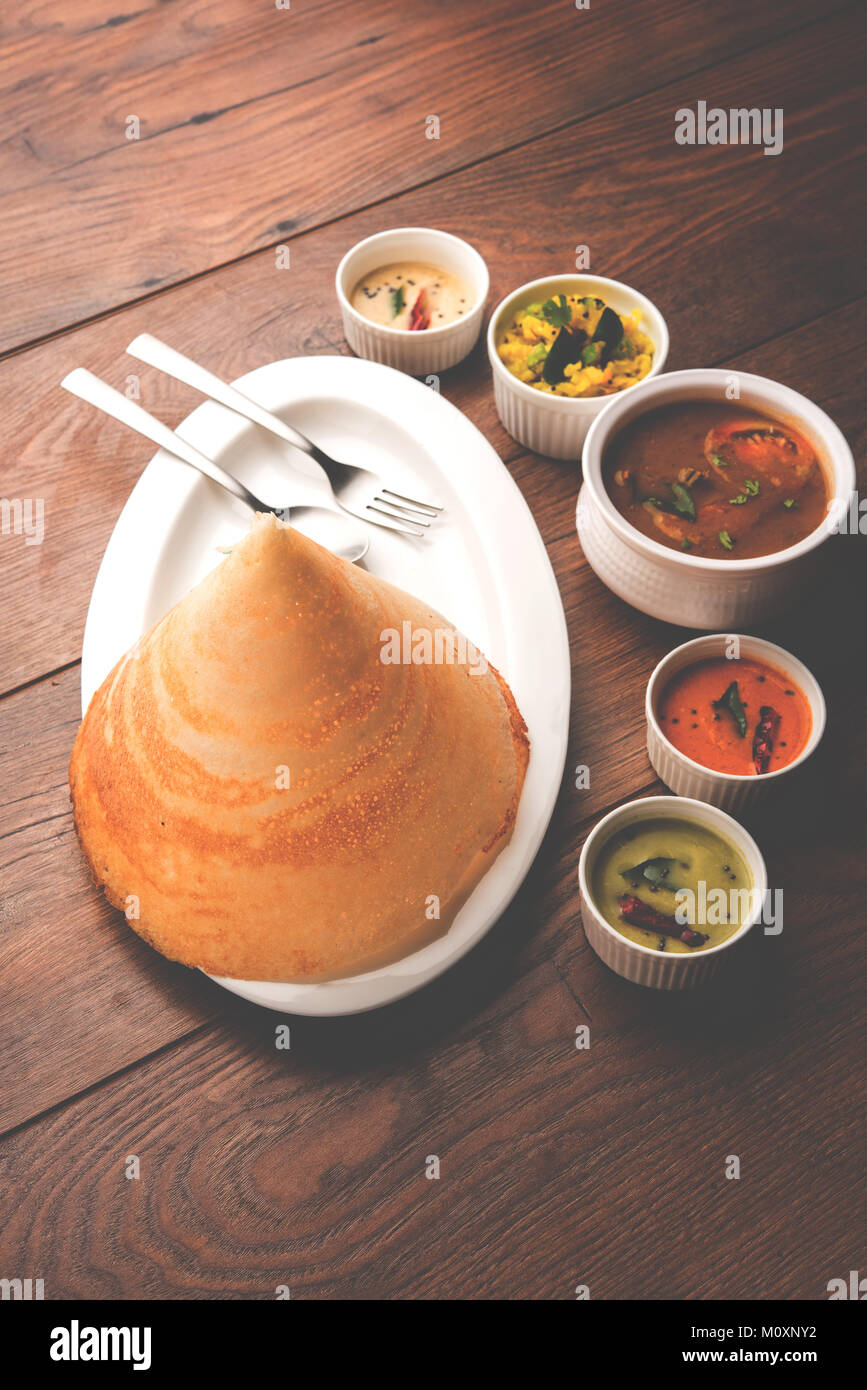 Masala dosa with chutney and sambar and potato sabzi. Cone, triangle or ...