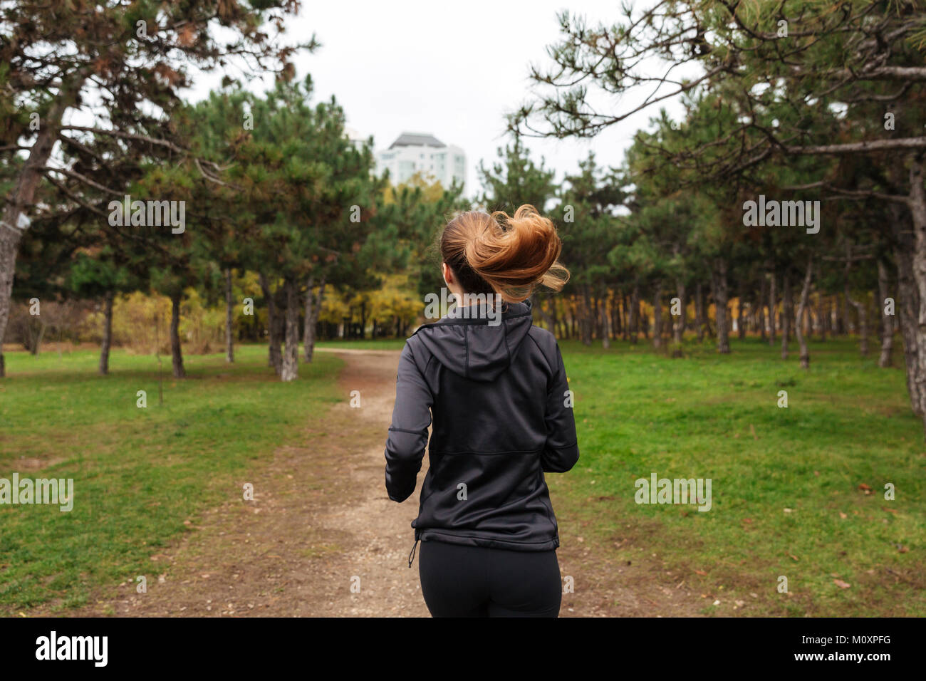 Back view of a young fitness woman jogging outdoors Stock Photo - Alamy