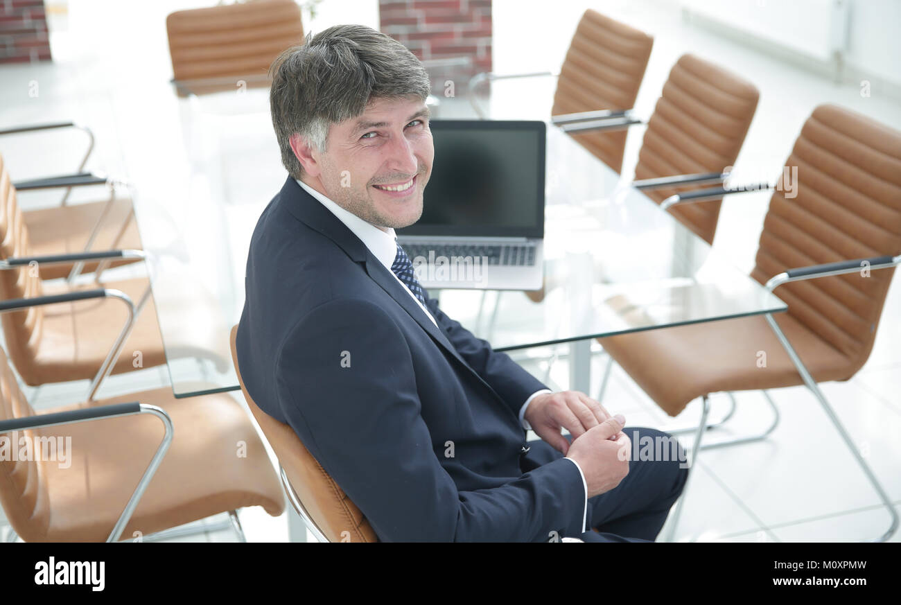 smiling manager sitting at work desk in meeting room Stock Photo - Alamy