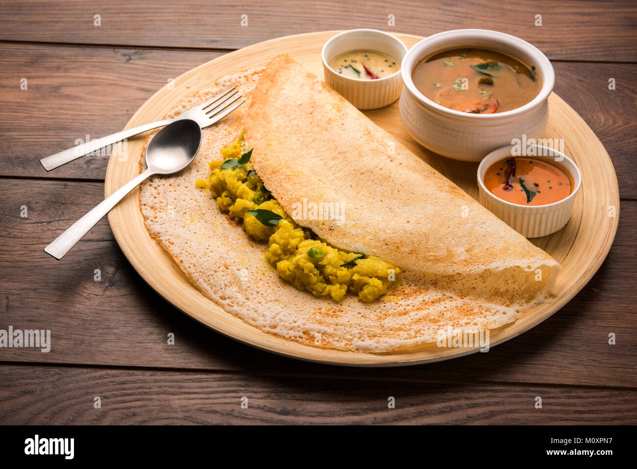 Masala dosa with chutney and sambar and potato sabzi. Cone, triangle or ...