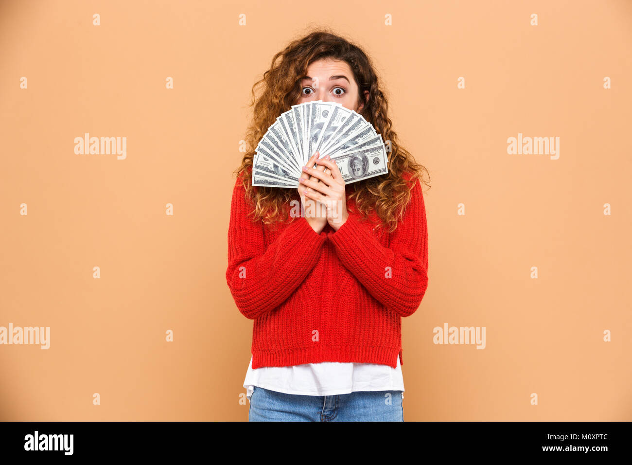 Portrait of a happy excited girl holding bunch of money banknotes at ...